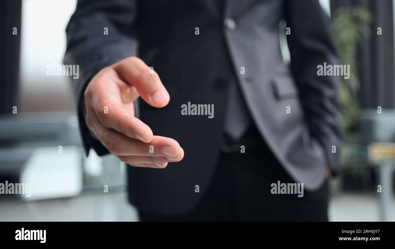 Elegant business man offering a handshake in the office Stock Photo - Alamy