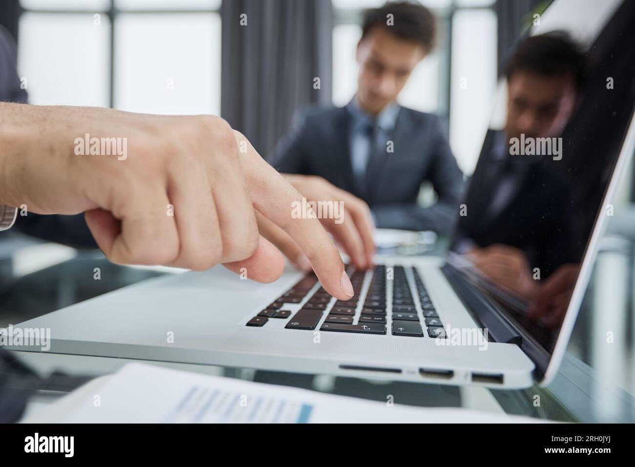 Men's hands are typing on a laptop keyboard against the background of ...