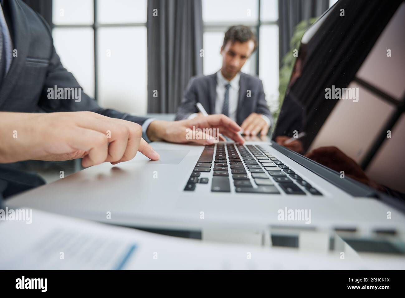 Men's hands are typing on a laptop keyboard against the background of ...
