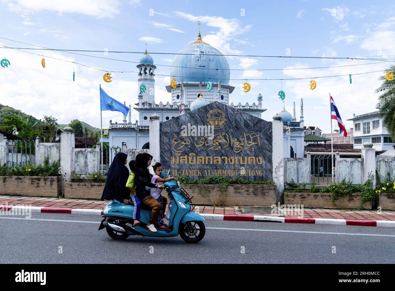 Betong, Thailand. 12th Aug, 2023. People ride past the Central Mosque ...