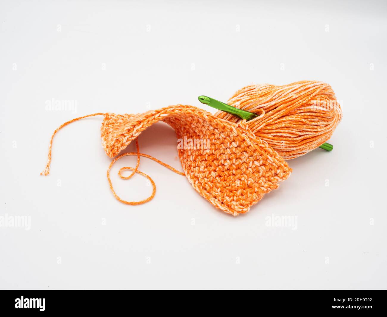 Isolated on a white background, there's pumpkin-colored yarn paired ...