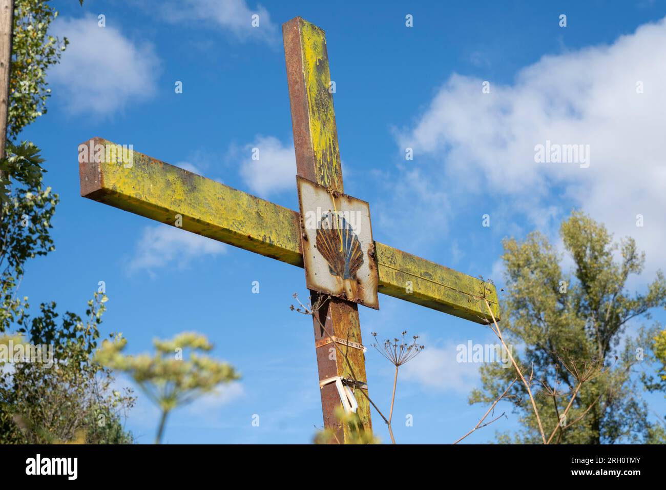 A weathered marker on a cross show pilgrims the way leaving the city ...