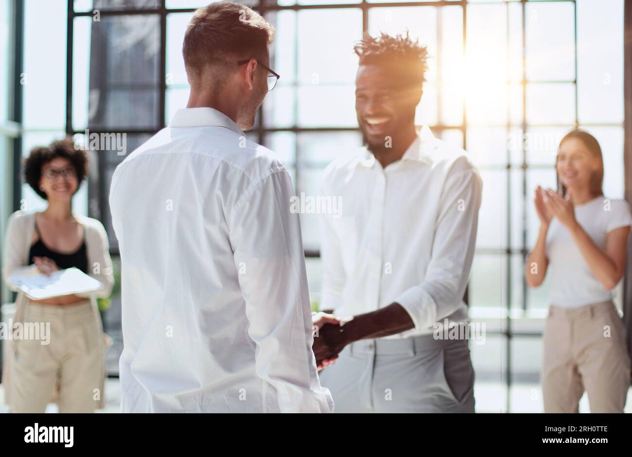 Congratulating the new partners in modern office Stock Photo - Alamy