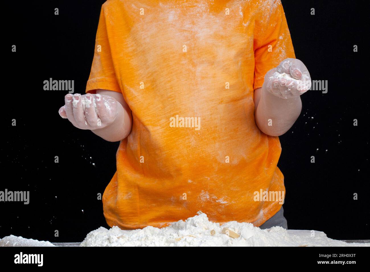 a child plays with flour while cooking, white wheat flour is gathering ...