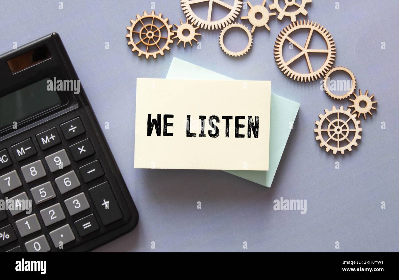 We listen text on a yellow sticker on a rope with clothespins on a red ...