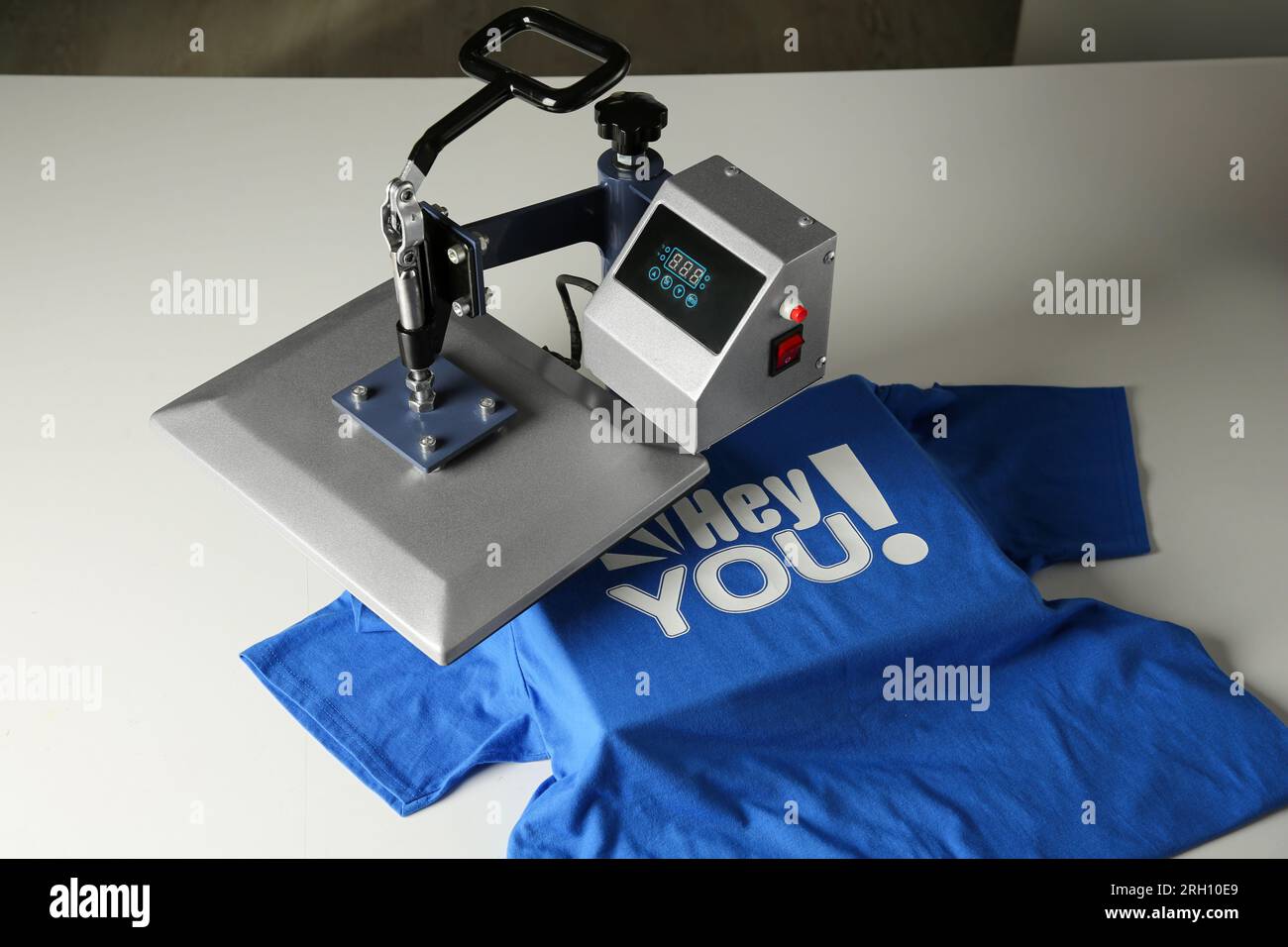 Printing logo. Heat press with blue t-shirt on white table Stock Photo ...
