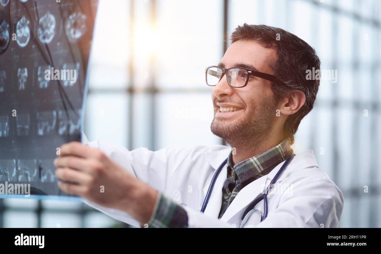 Doctor looking MRI picture on gray background Stock Photo - Alamy