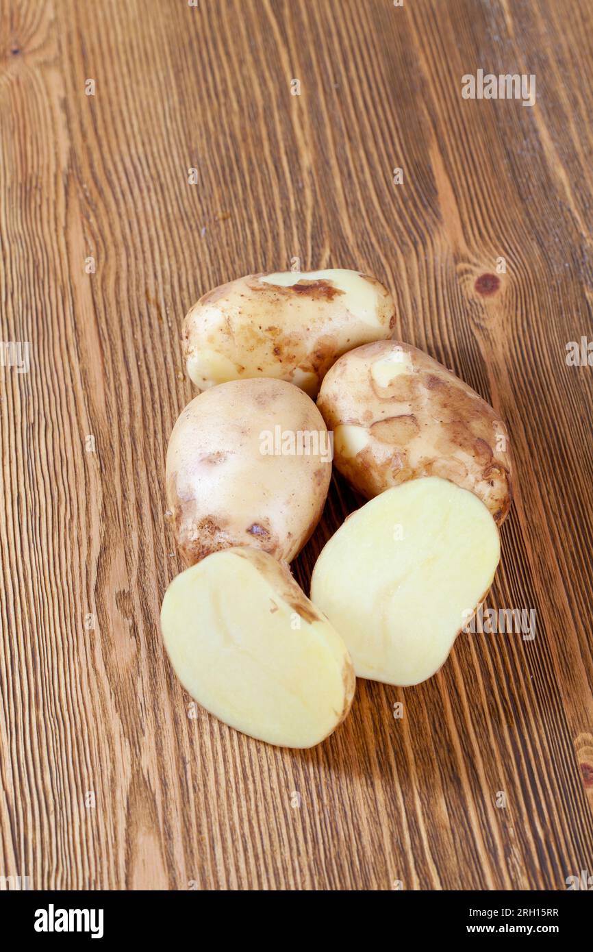 washed recently ripened potatoes on a wooden table, fresh new potato ...