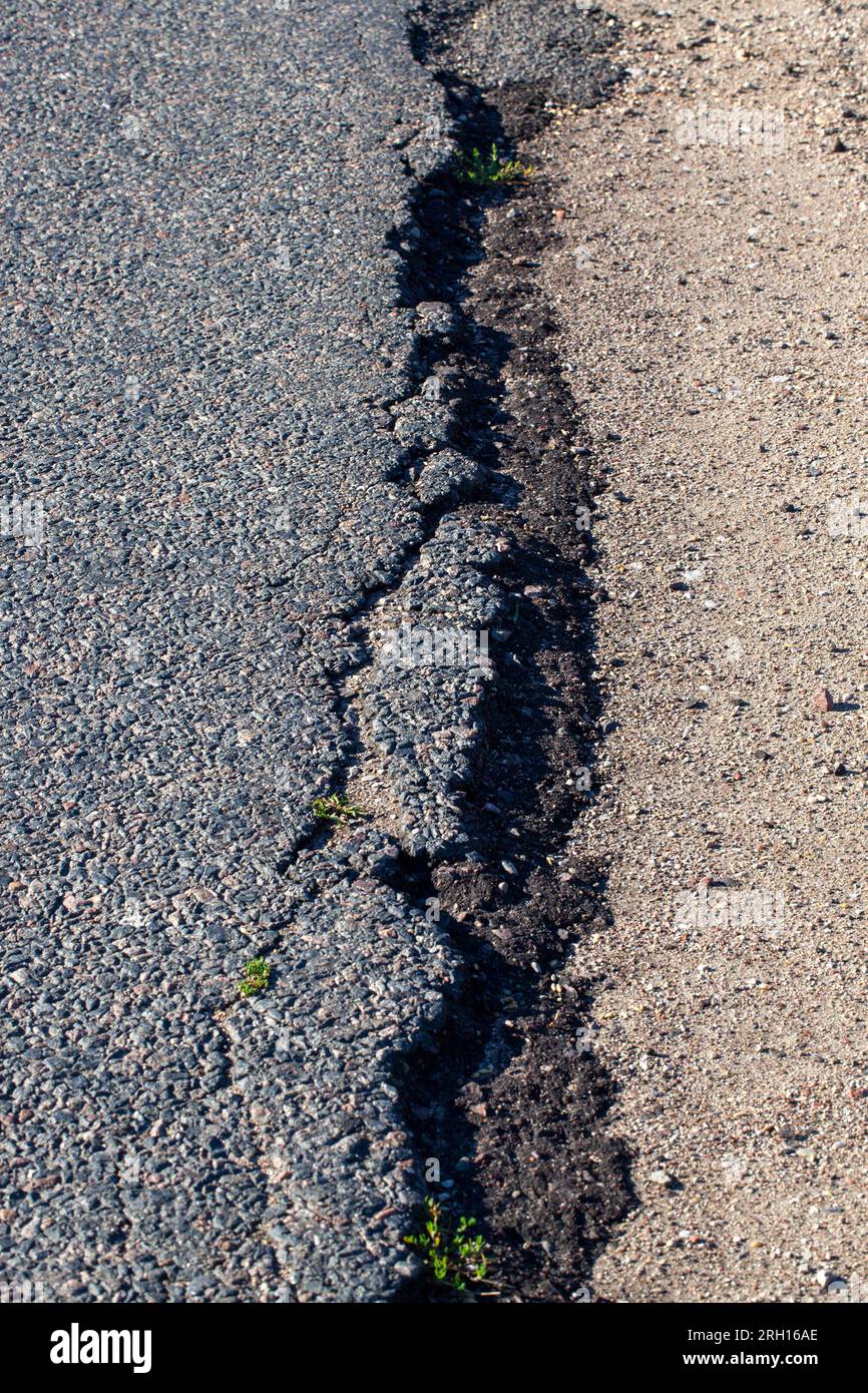 details of an asphalt road with cracks and holes, part of the ...