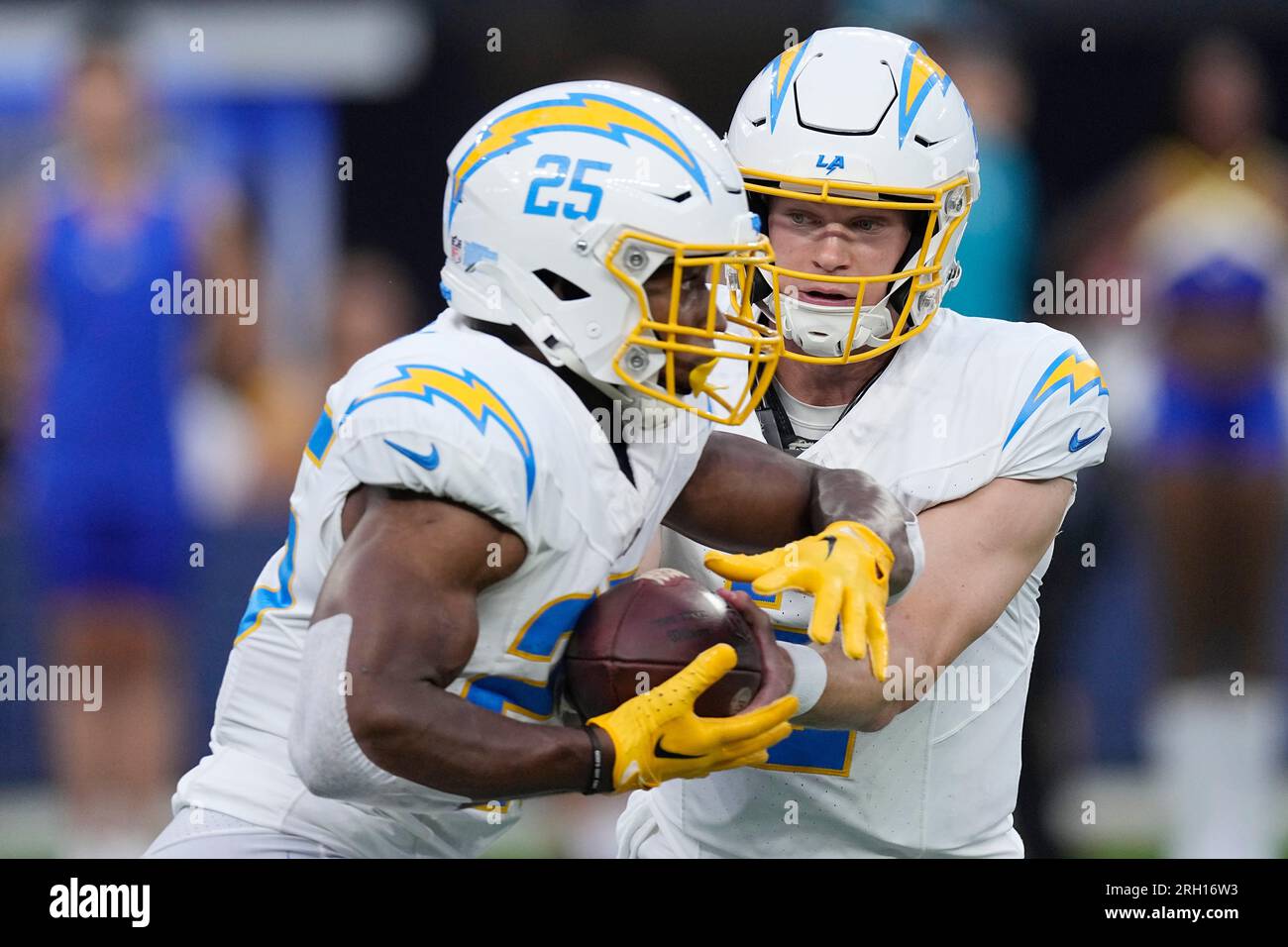 Los Angeles Chargers quarterback Easton Stick, right, hands off to ...