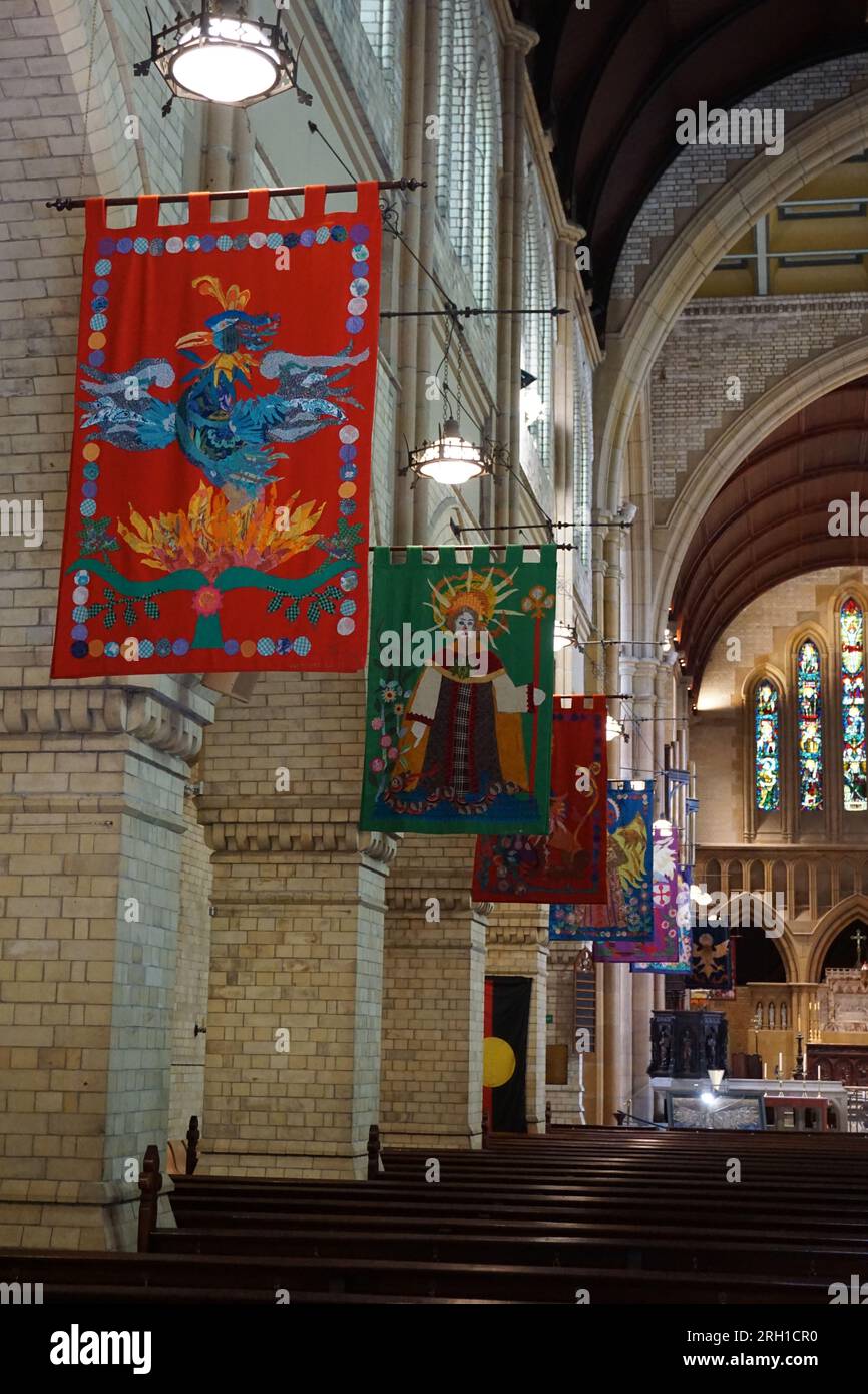 interior of a gothic revival cathedral, with colorful hand sown banners ...