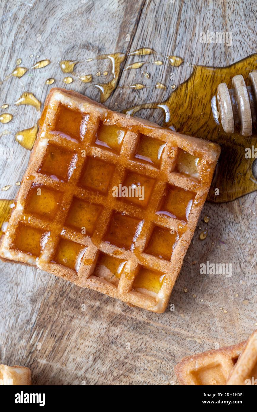 square sweet soft waffles in bee honey , a traditional European dessert ...