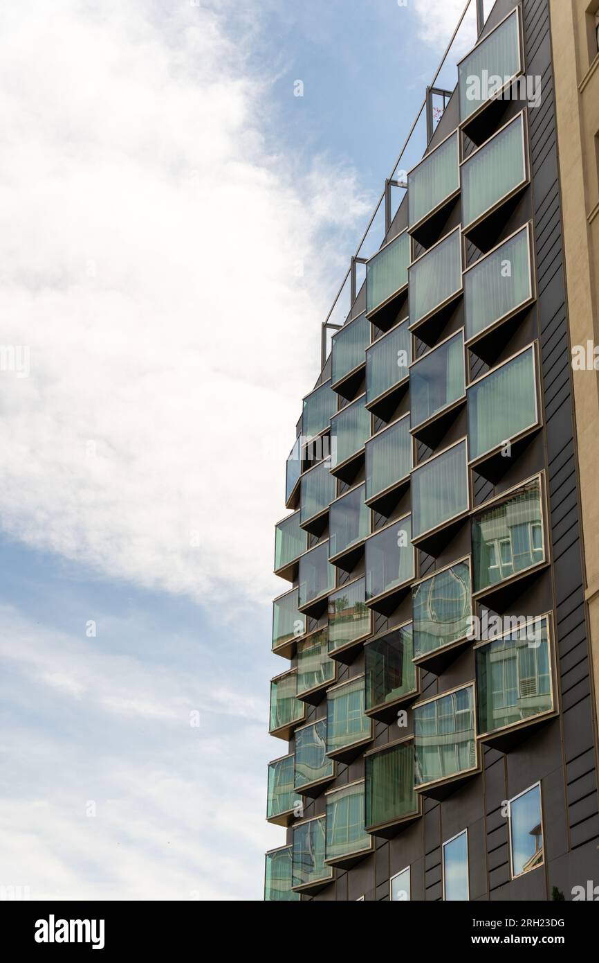 Looking up view of rotated diagonal glass facade with windows of modern ...
