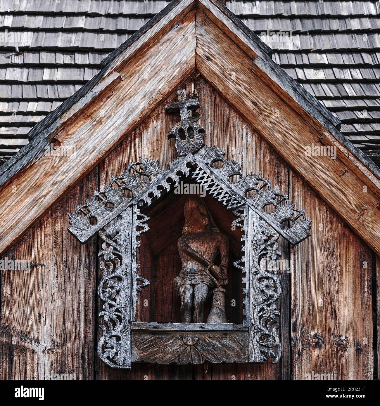 Figure of Christ tethered to post, carved in wood. In gable niche of ...