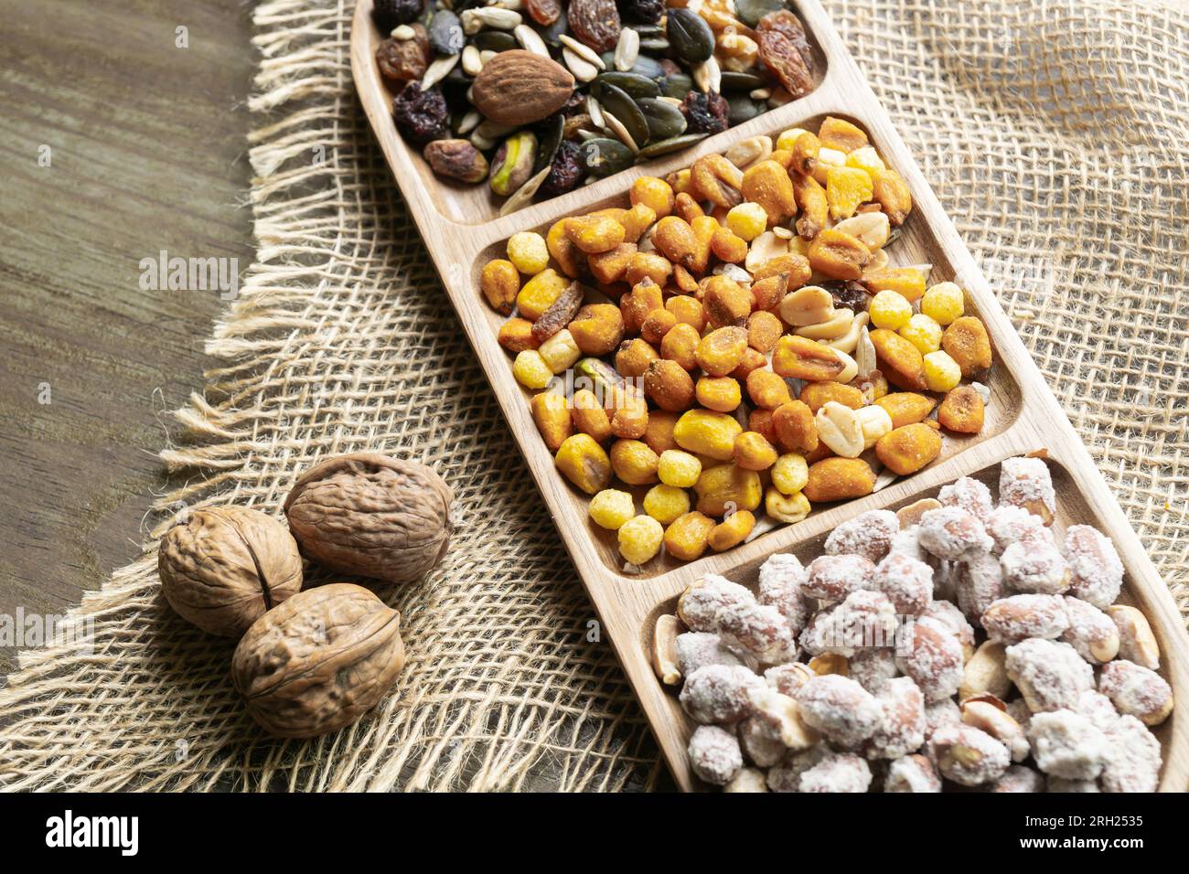 Dried fruits and seeds on a bamboo tray and walnuts. Horizontal flat ...