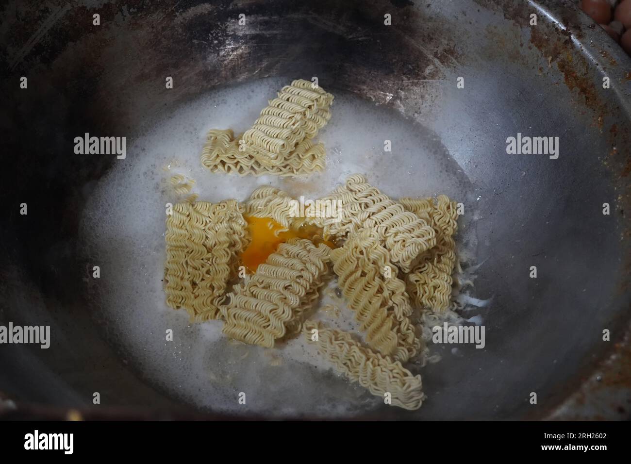 Prepare Indonesian instant noodles in a large frying pan with eggs in ...