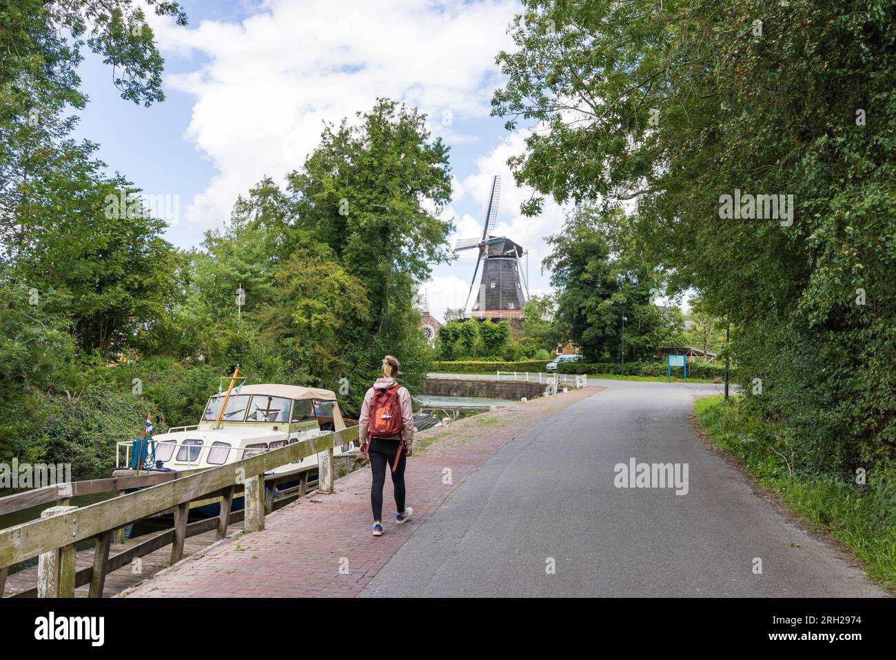 Street view with hiker walking across little village Pieterburen in Het ...