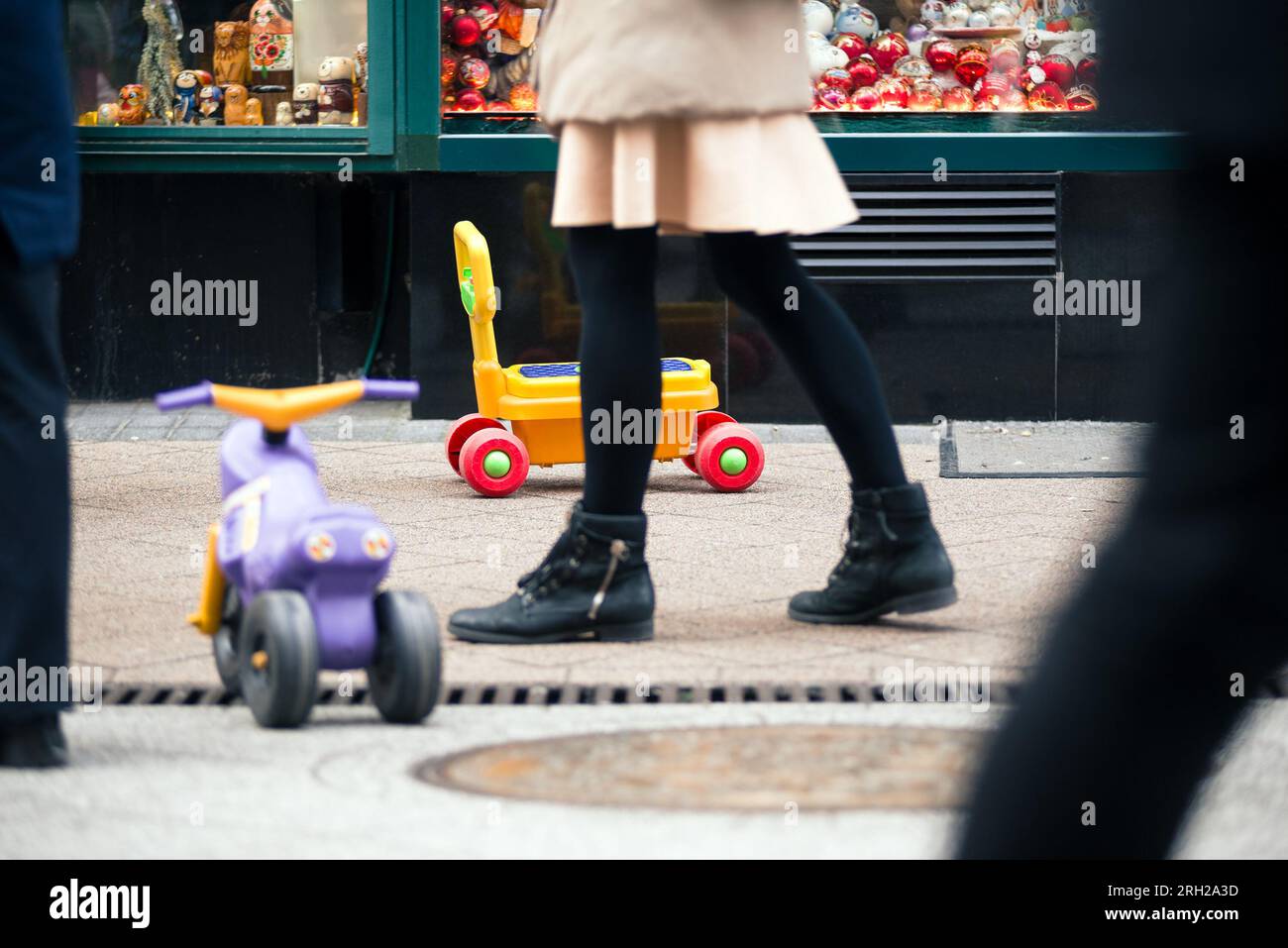 Toys on the street, feet of woman passing Stock Photo - Alamy