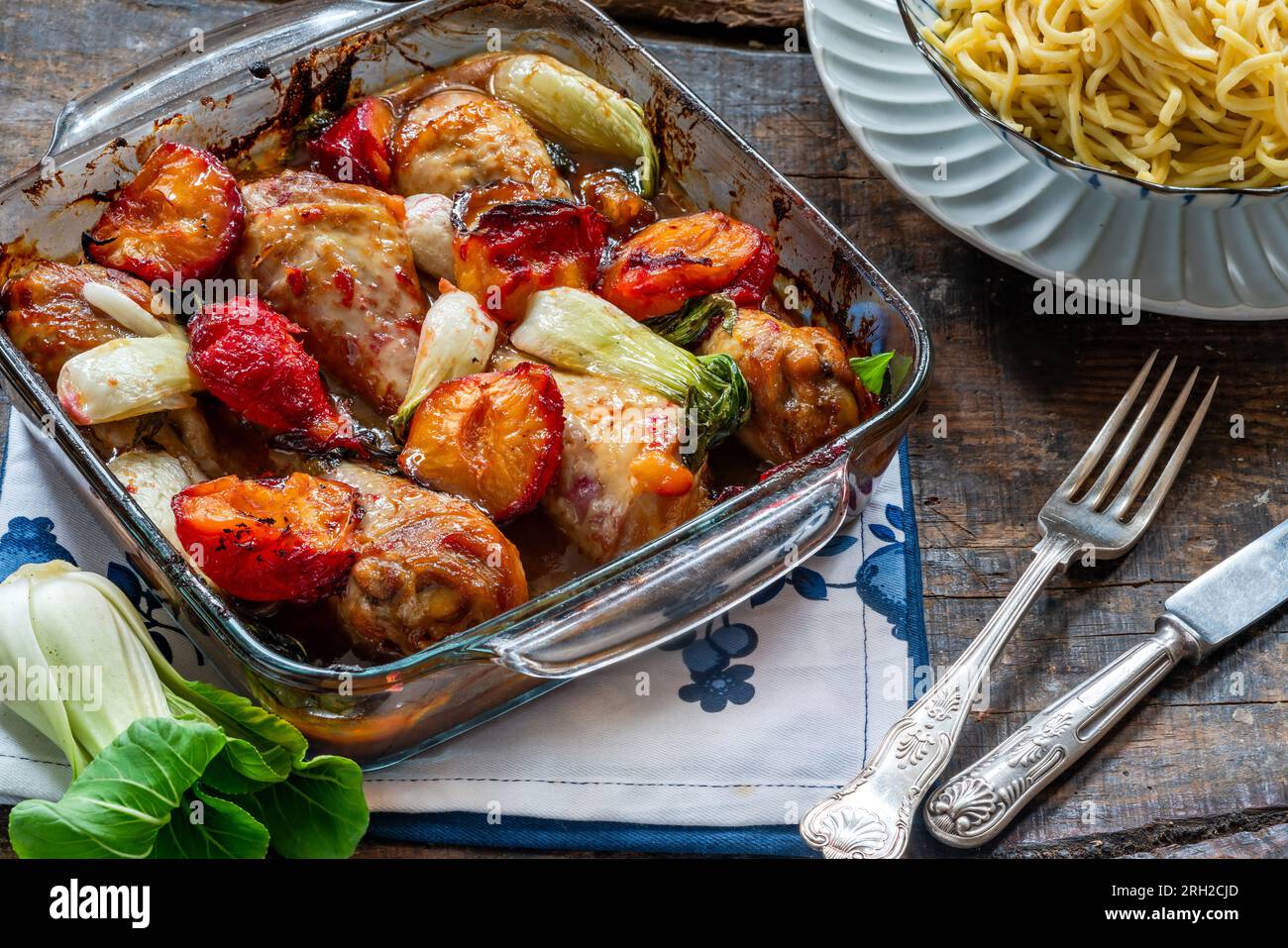 Chicken drumsticks with plums and pak choi Stock Photo - Alamy