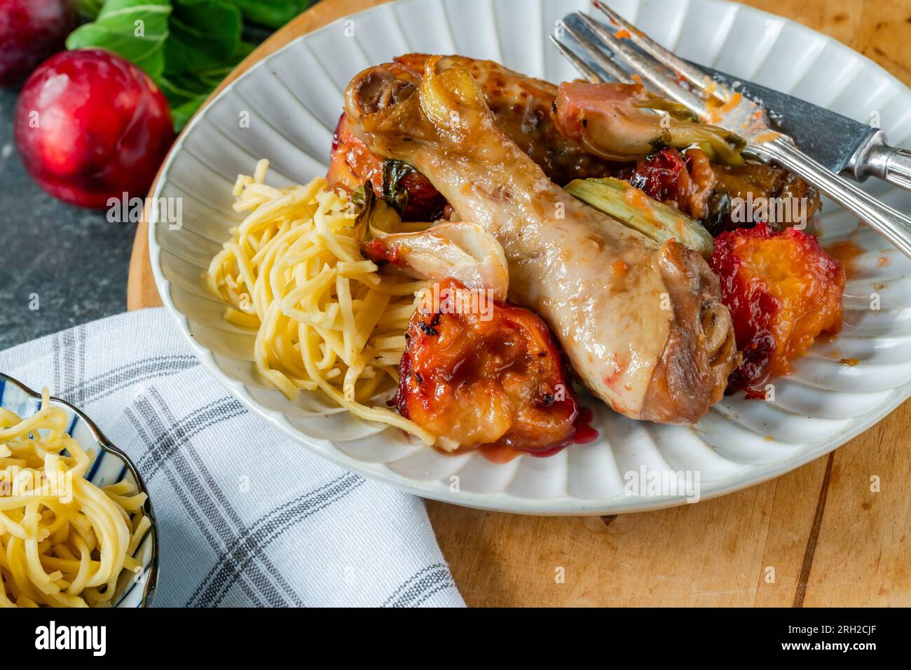 Chicken drumsticks with plums and pak choi Stock Photo - Alamy