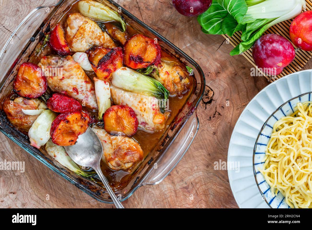 Chicken drumsticks with plums and pak choi Stock Photo - Alamy