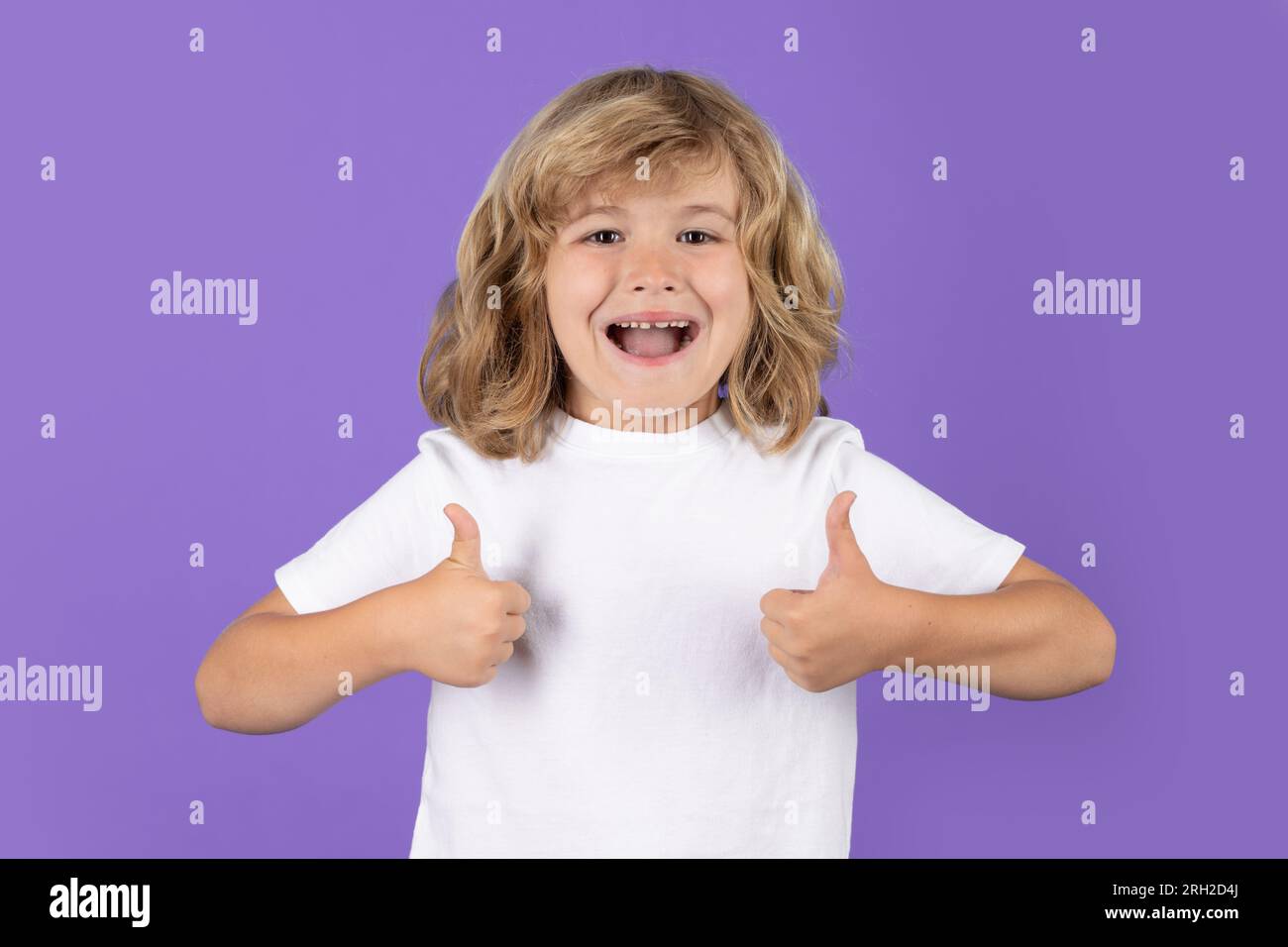 Excited kid boy with thumbs up on studio isolated background. Surprised ...