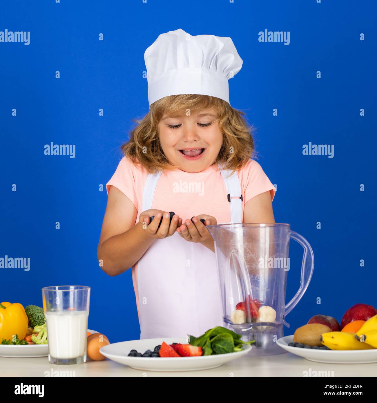 Cooking children. Chef kid boy making fresh vegetables for healthy eat ...