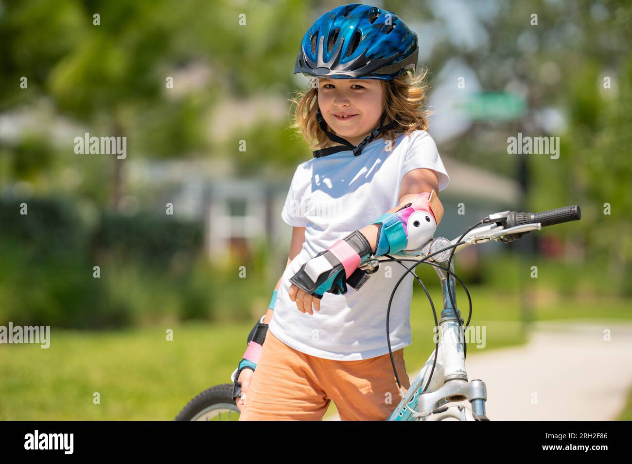 Child riding a bike in summer park. Children learning to drive a ...
