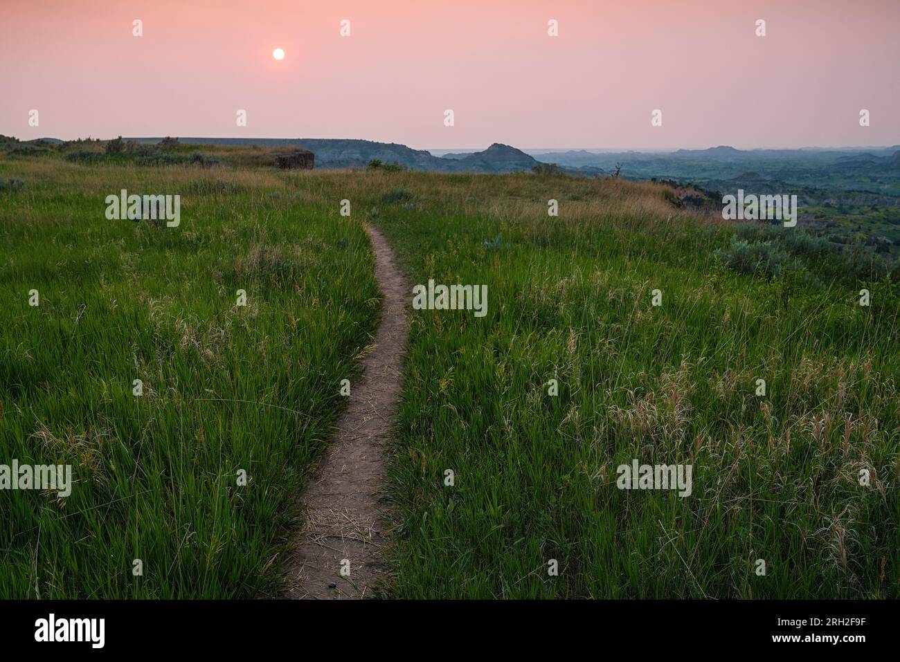 Hazy summer sunset muted by wildfire smoke over Theodore Roosevelt ...