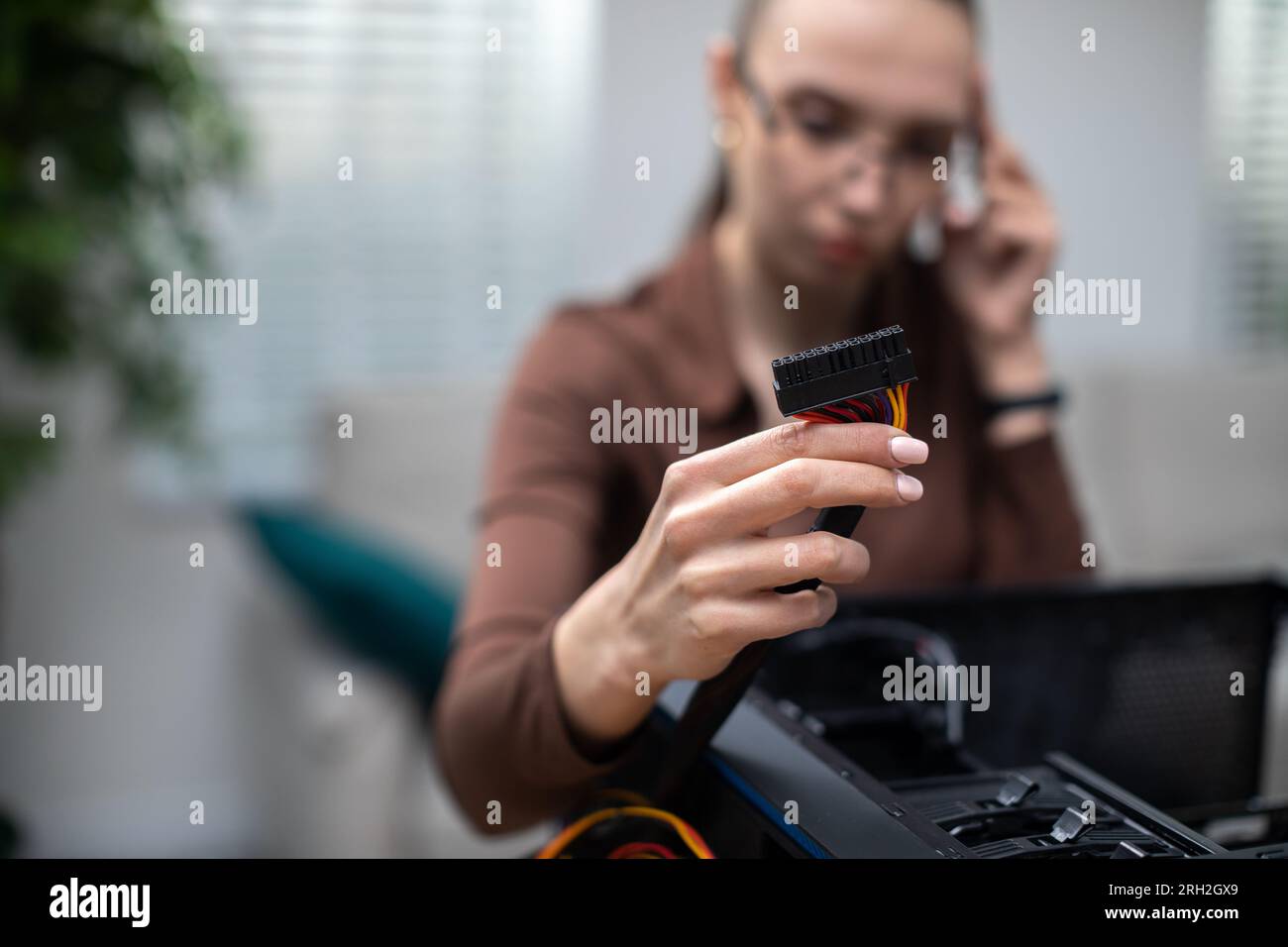 A woman repairing a broken computer in an office at a table Stock Photo ...