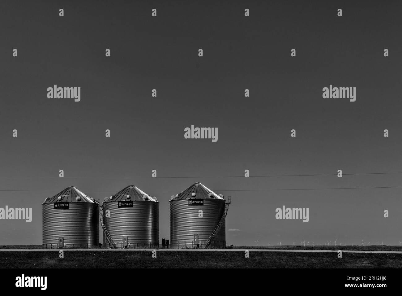 Black and white image of three Superior grain silos under a clear ...