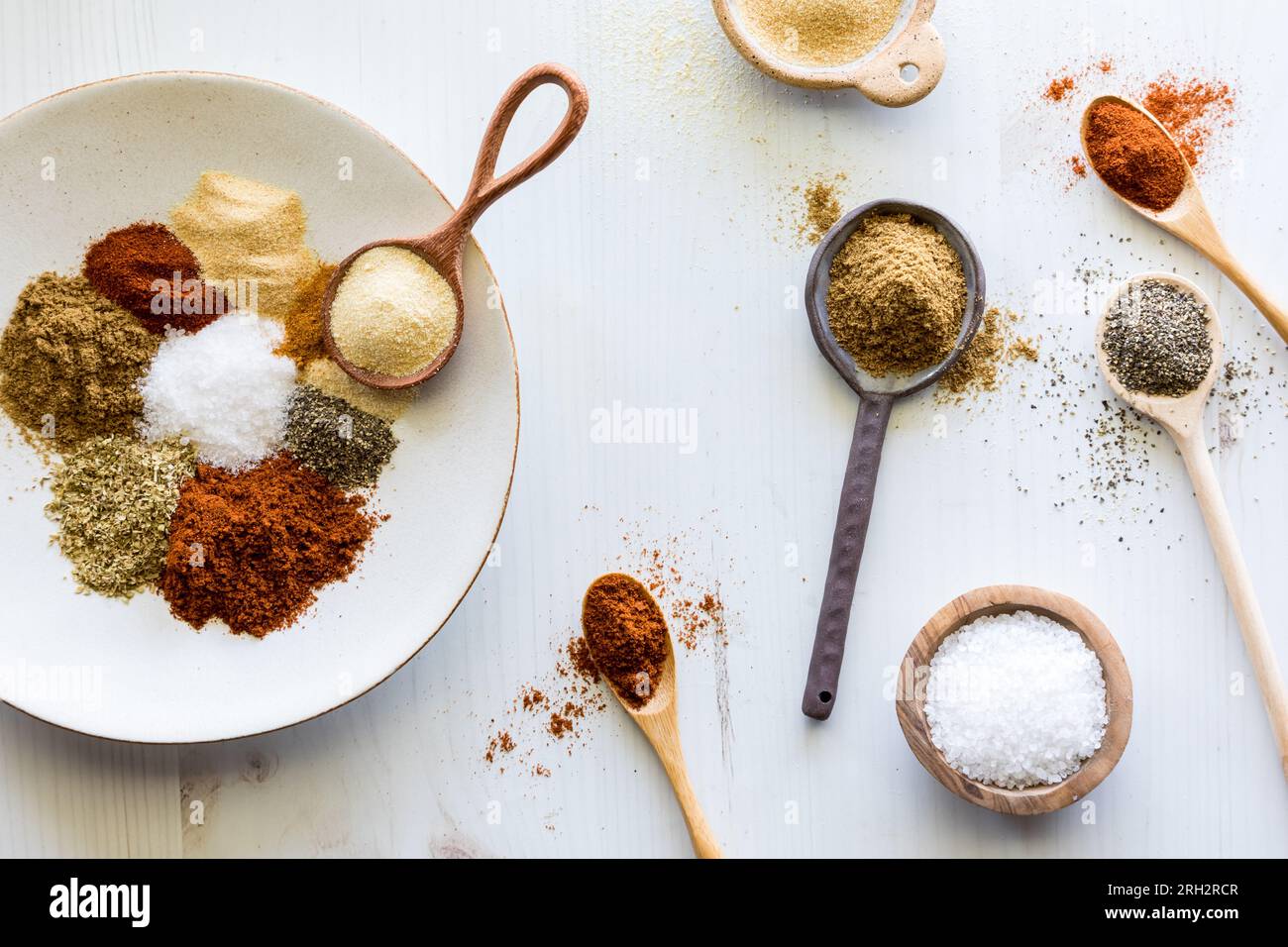 Piles of spices on various spoons and a plate with copy space in the ...