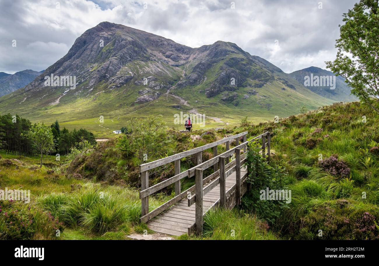Hiker walking down the Devil's Staircase towards the Pass of Glencoe in ...