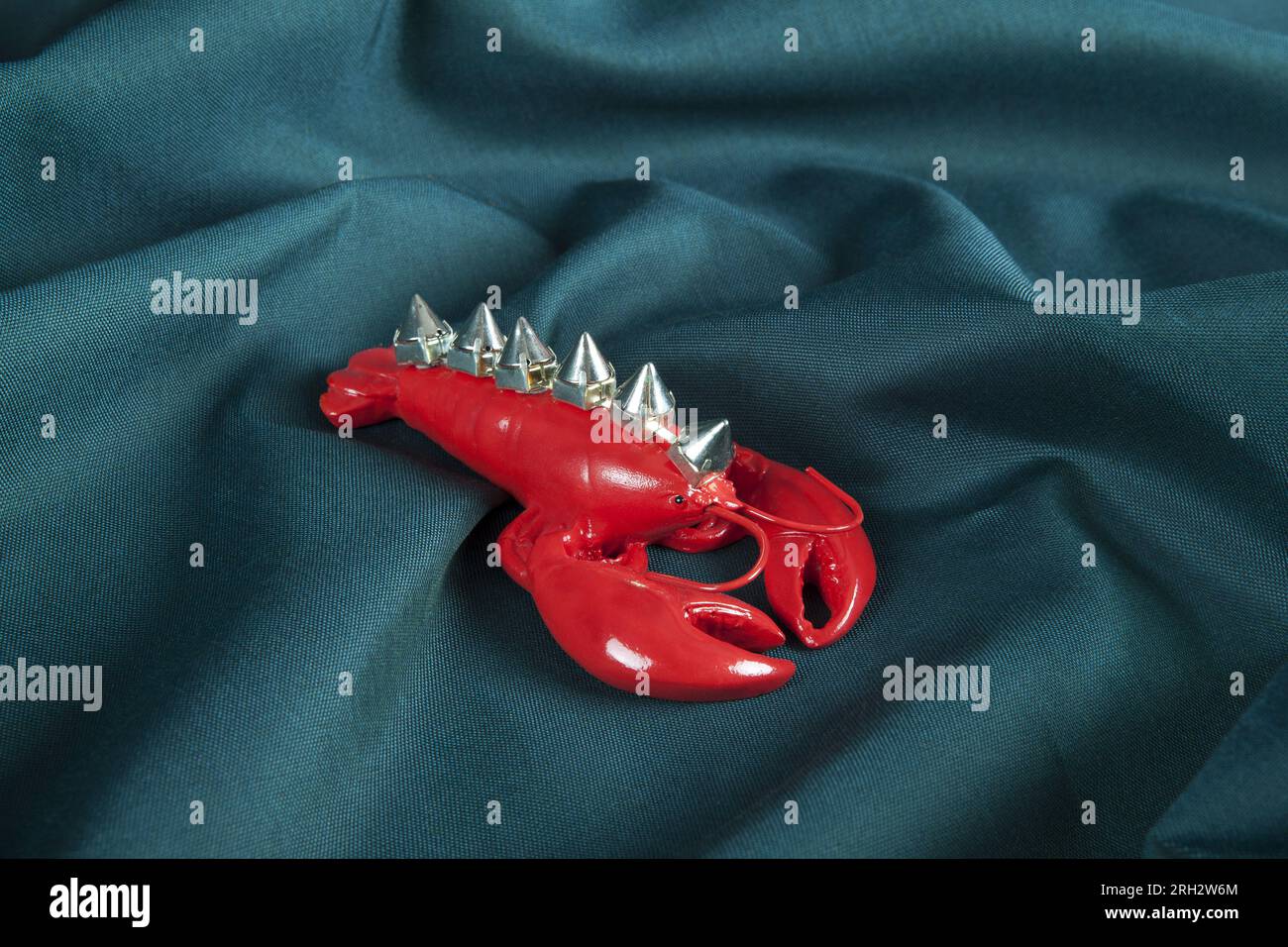 a punk style lobster wearing riveted spikes like a mohican on a green ...