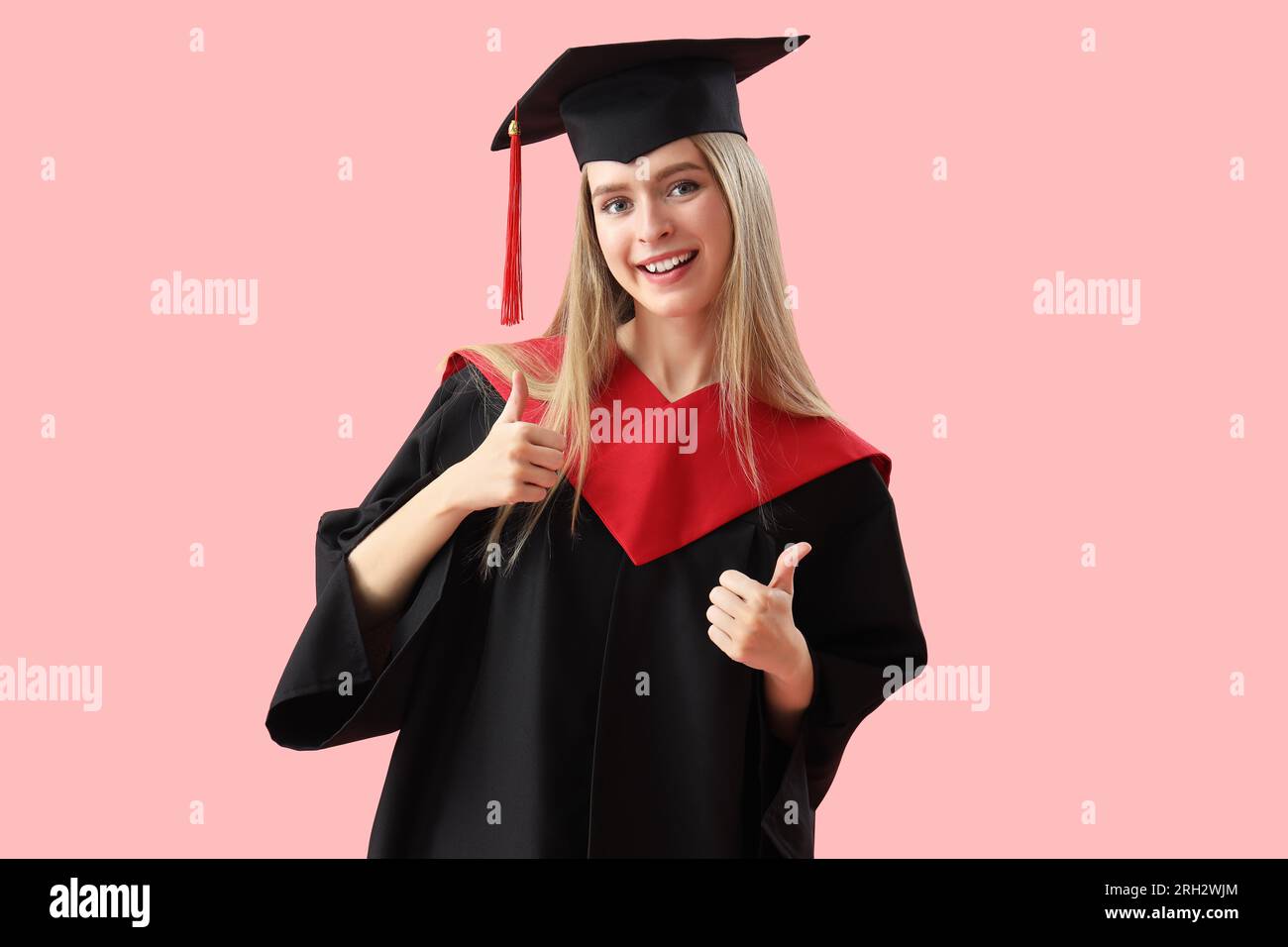 Female graduate student showing thumbs-up on pink background Stock ...