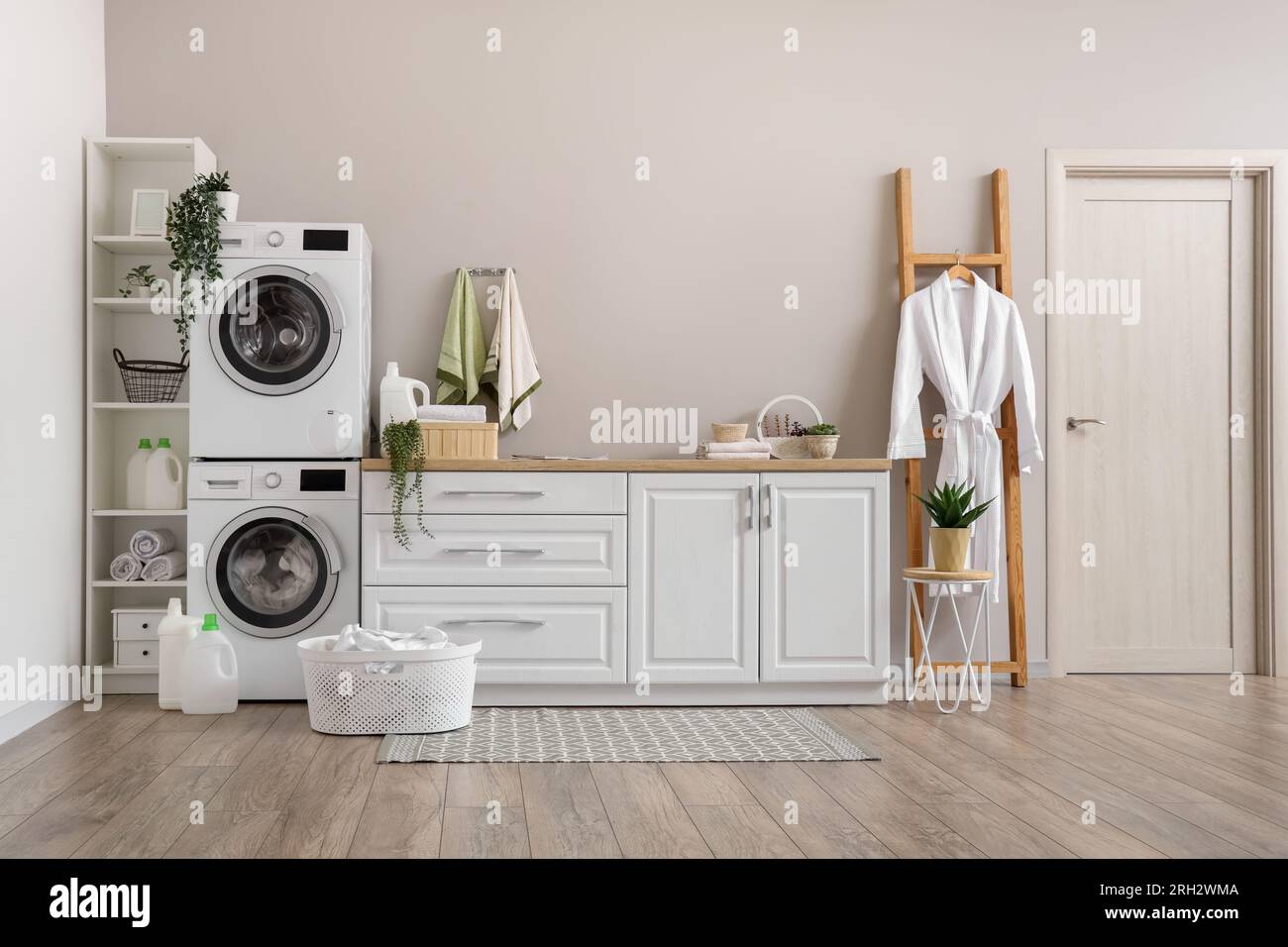 Laundry room with washing machines and white counters Stock Photo - Alamy