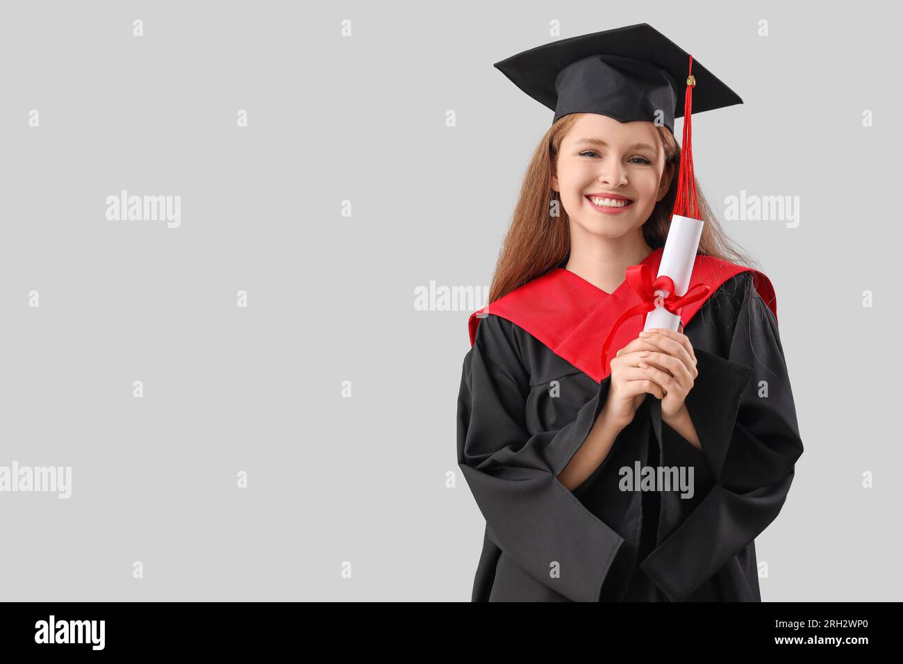Female graduate student with diploma on grey background Stock Photo - Alamy