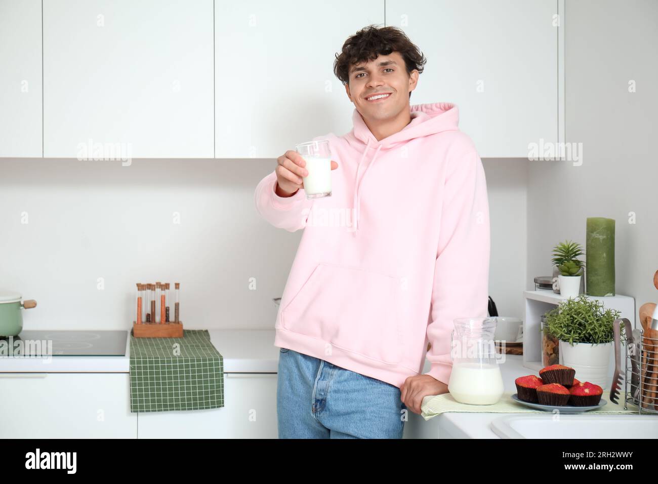 Young man drinking fresh milk in kitchen Stock Photo - Alamy