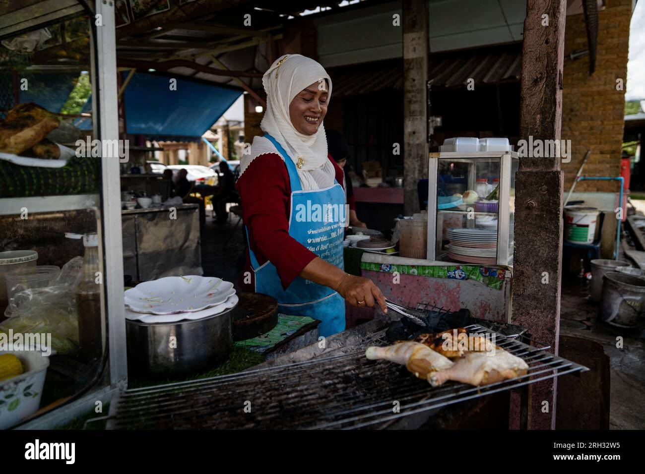 Betong, Thailand. 13th Aug, 2023. A street food vendor grills chicken ...