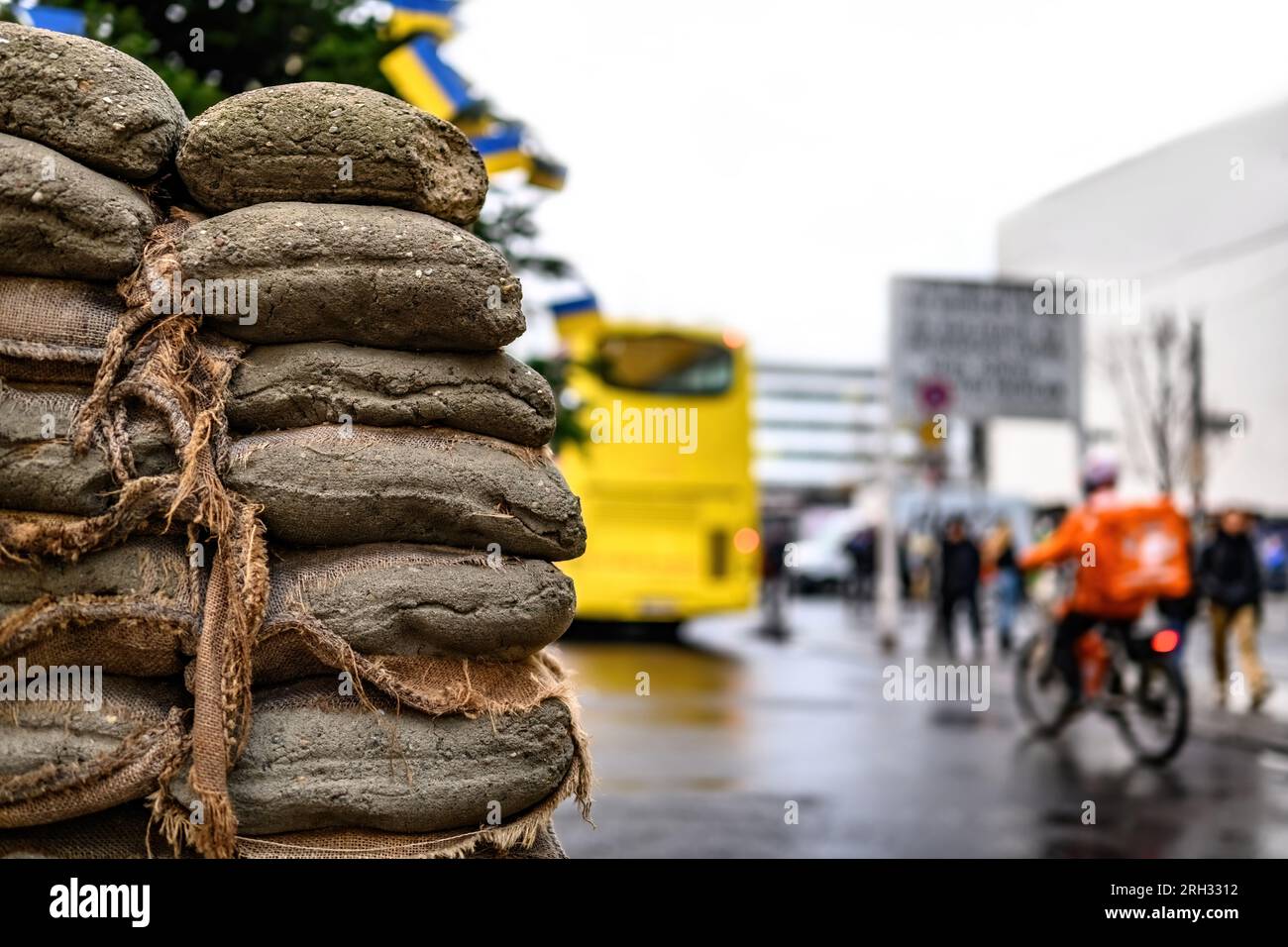 Sacks with sand at Checkpoint Charlie against hop-on hop-off touristic ...