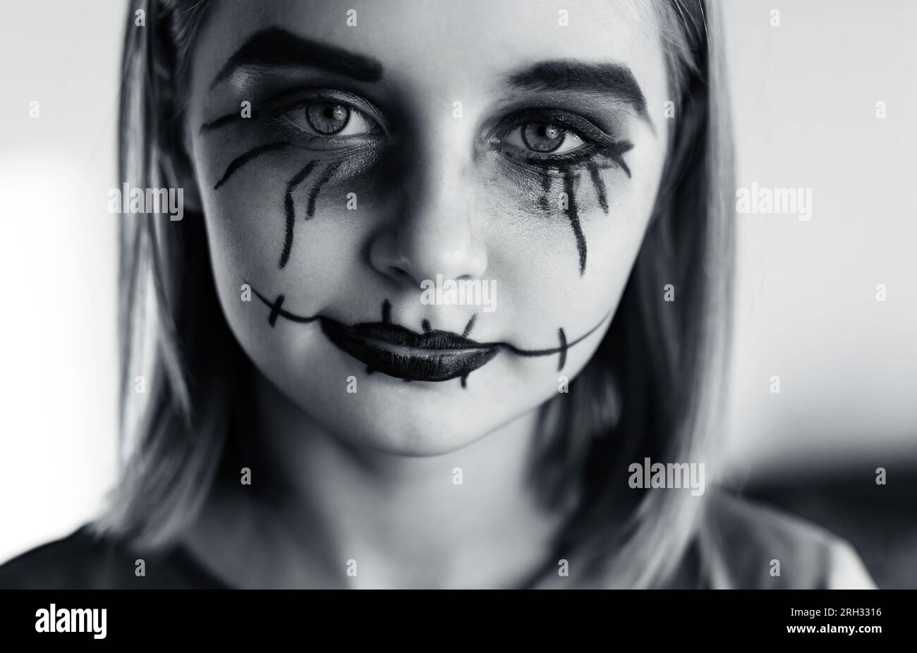 Little girl with spooky Halloween makeup brushed eyes looking at camera ...