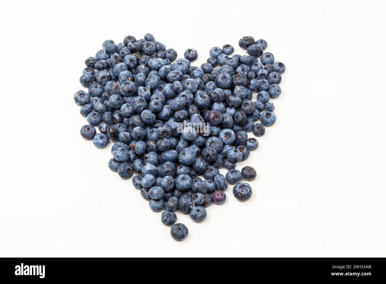 A heart of blueberries in different sizes on a white background ...