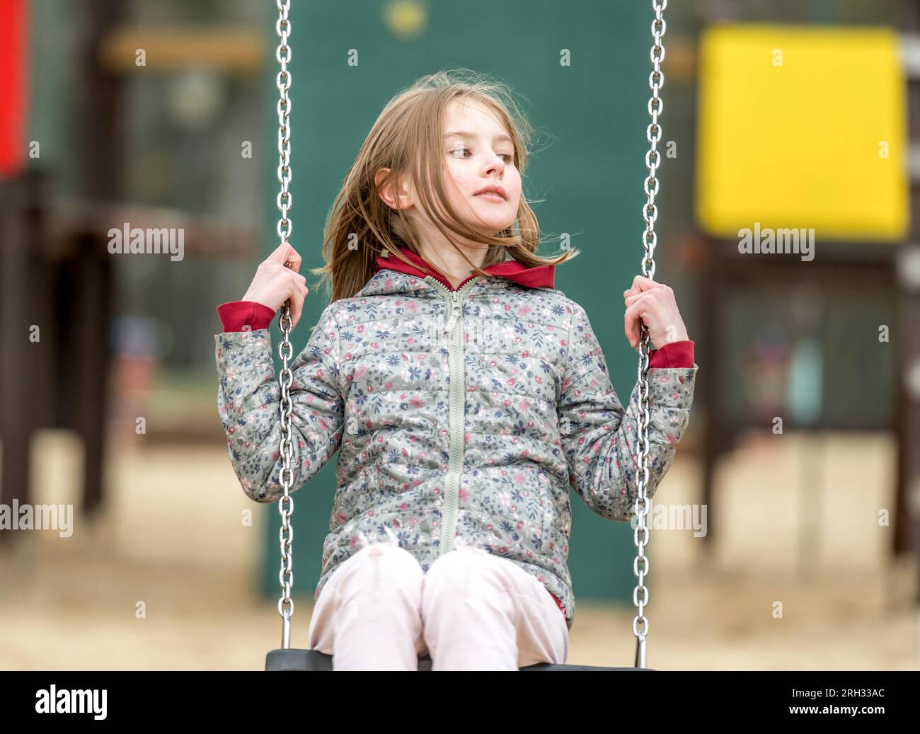 Cute little girl riding a chain swing in a autumn park Stock Photo - Alamy