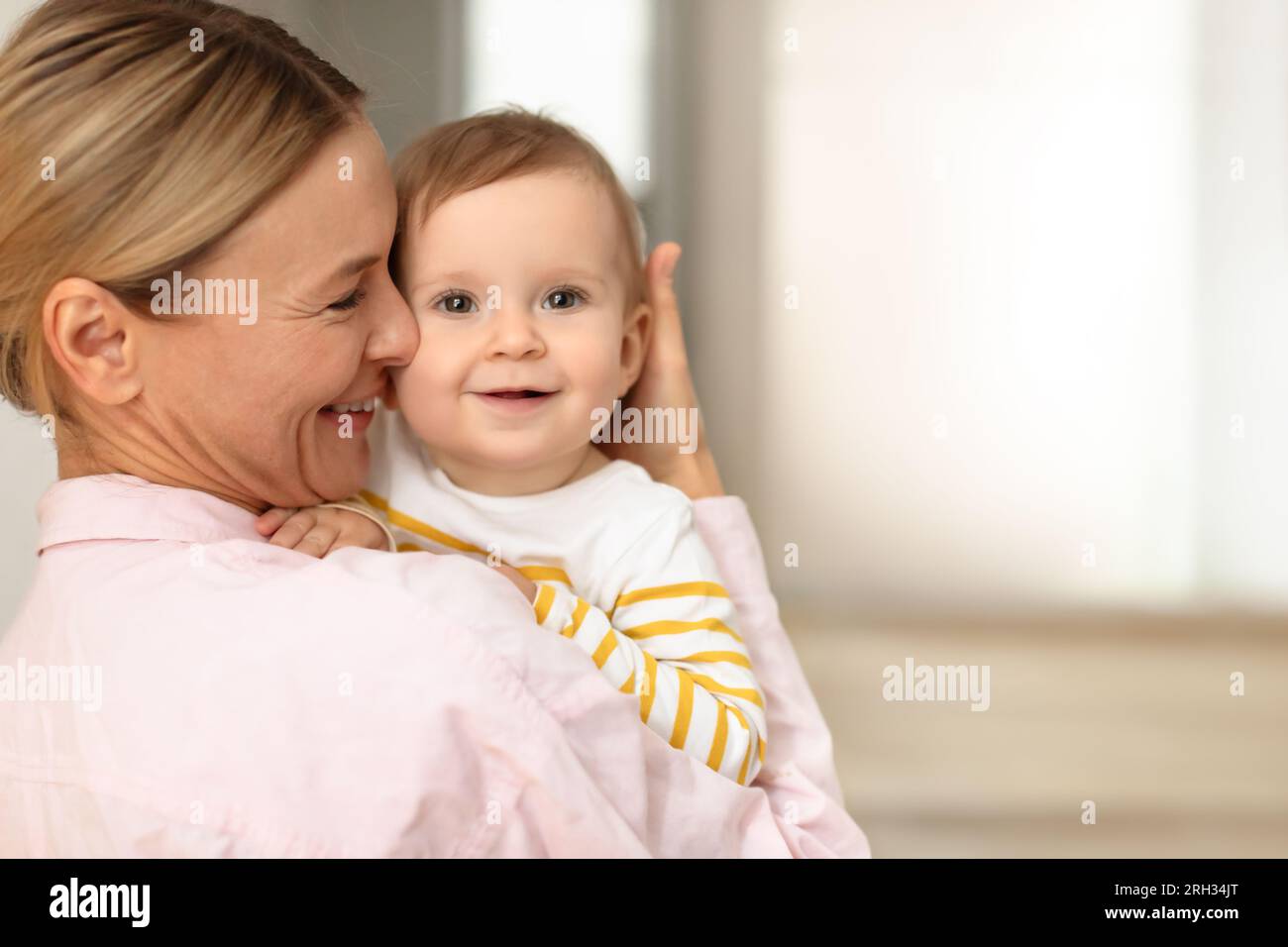 Joy of motherhood. Loving mother rubbing nose on baby daughter's cheek ...