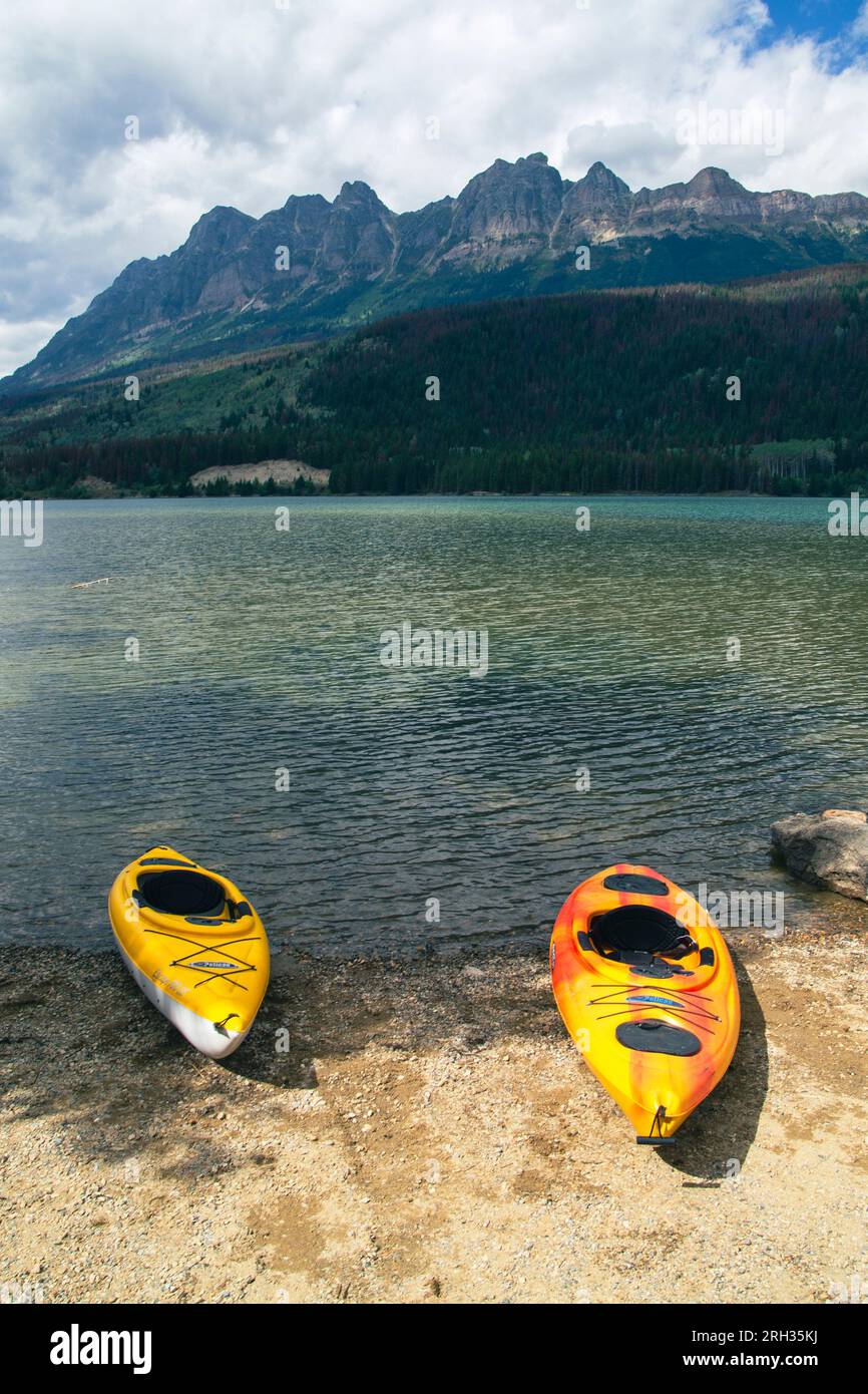 Two colourful kayaks rest on the edge of a lake in the Canadian ...