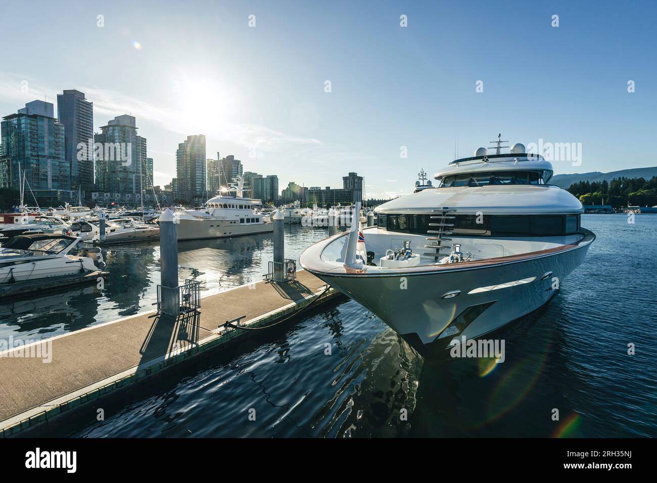 An impressive private yacht is moored with smaller boats in the harbour ...