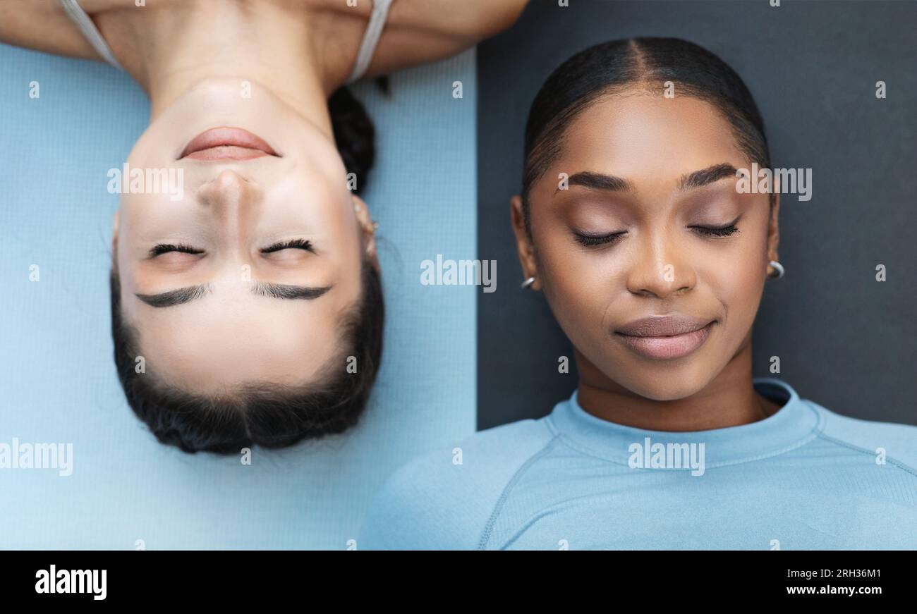 Calm glad young diverse women athletes with closed eyes practice yoga ...