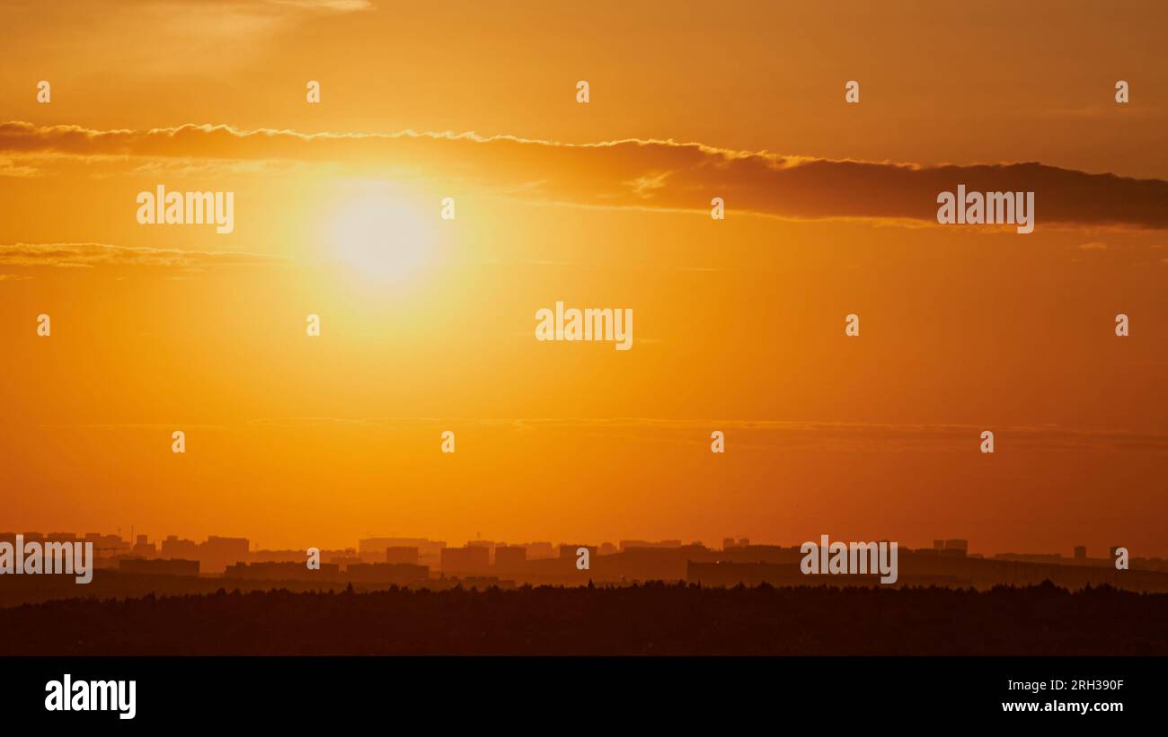 The large, orange sun slowly sank below the horizon, leaving behind a ...