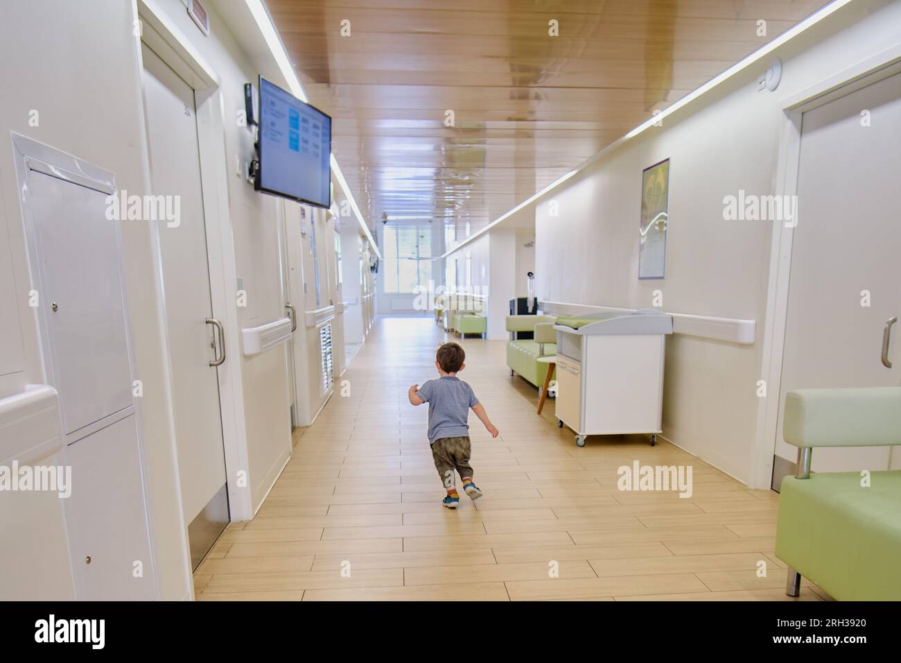 A child runs down a long corridor of a modern clinic Stock Photo - Alamy