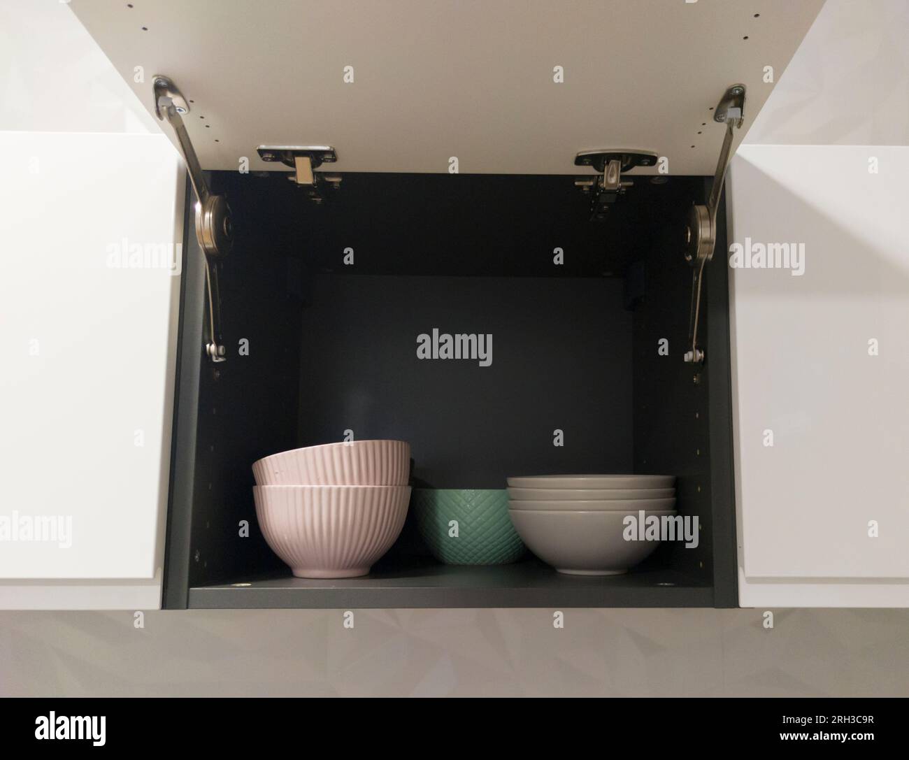 Top kitchen cupboard showing dishware. Handleless cupboards concept ...